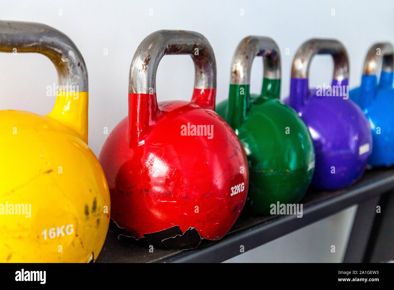 Row of colourful kettlebells, lifting weights Stock Photo - Alamy