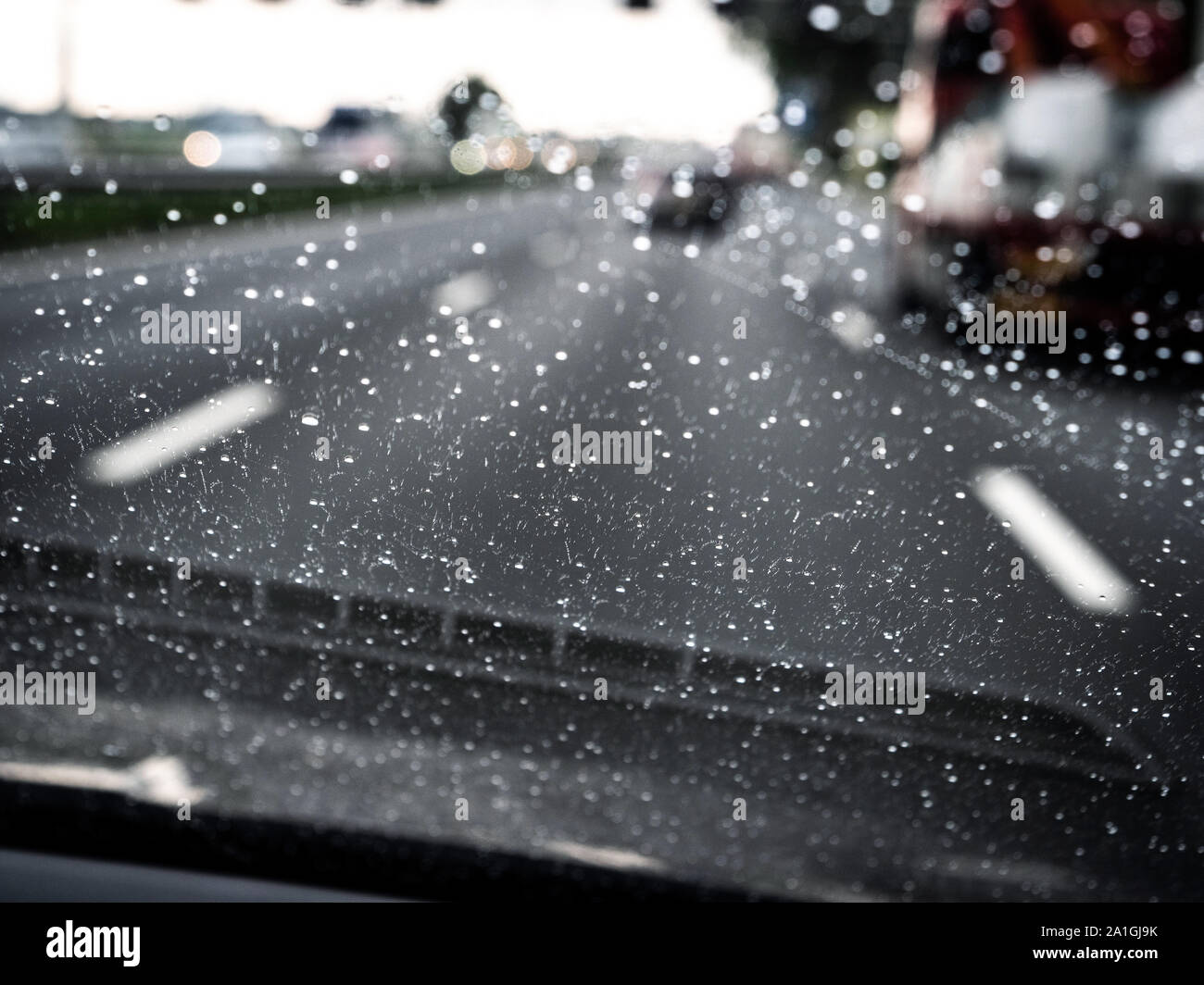 Driver POV of car driving on rainy highway with rain drops from a storm ...