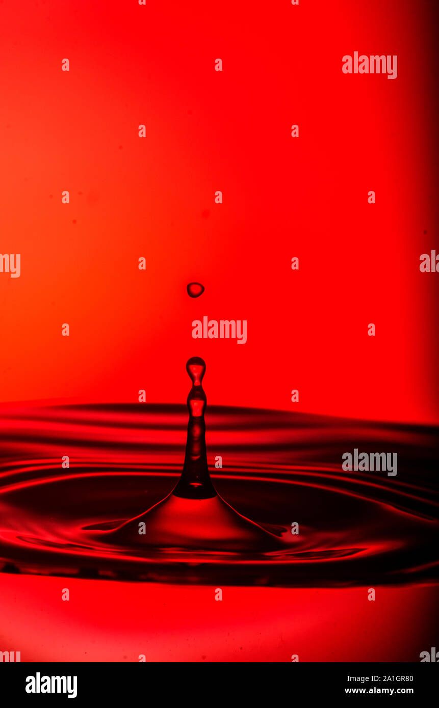 Water drop falling on red hi-res stock photography and images - Alamy
