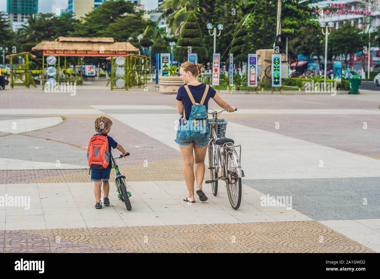 Happy family is riding bikes outdoors and smiling. Mom on a bike and ...