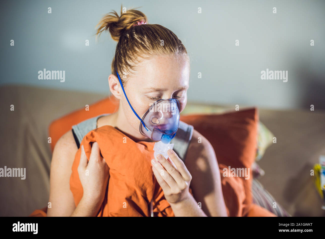 Woman with flu or cold symptoms making inhalation with nebulizer ...