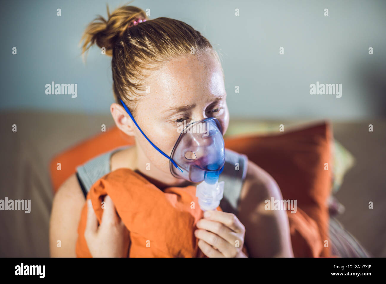 Woman with flu or cold symptoms making inhalation with nebulizer ...