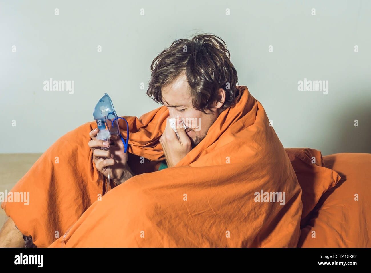 man with flu or cold symptoms making inhalation with nebulizer ...