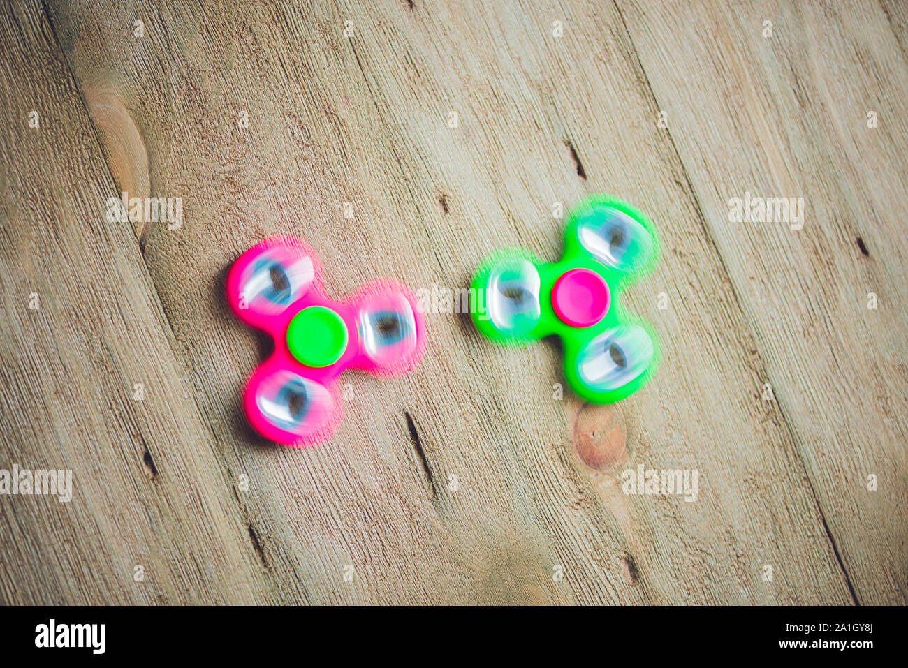 Colored fidget spinners stress relieving toy on wooden background Stock ...