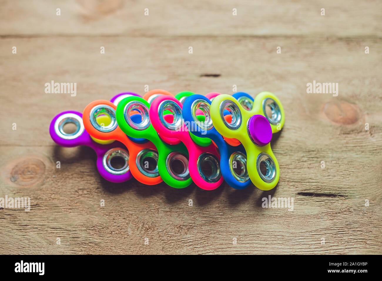 Colored fidget spinners stress relieving toy on wooden background Stock ...