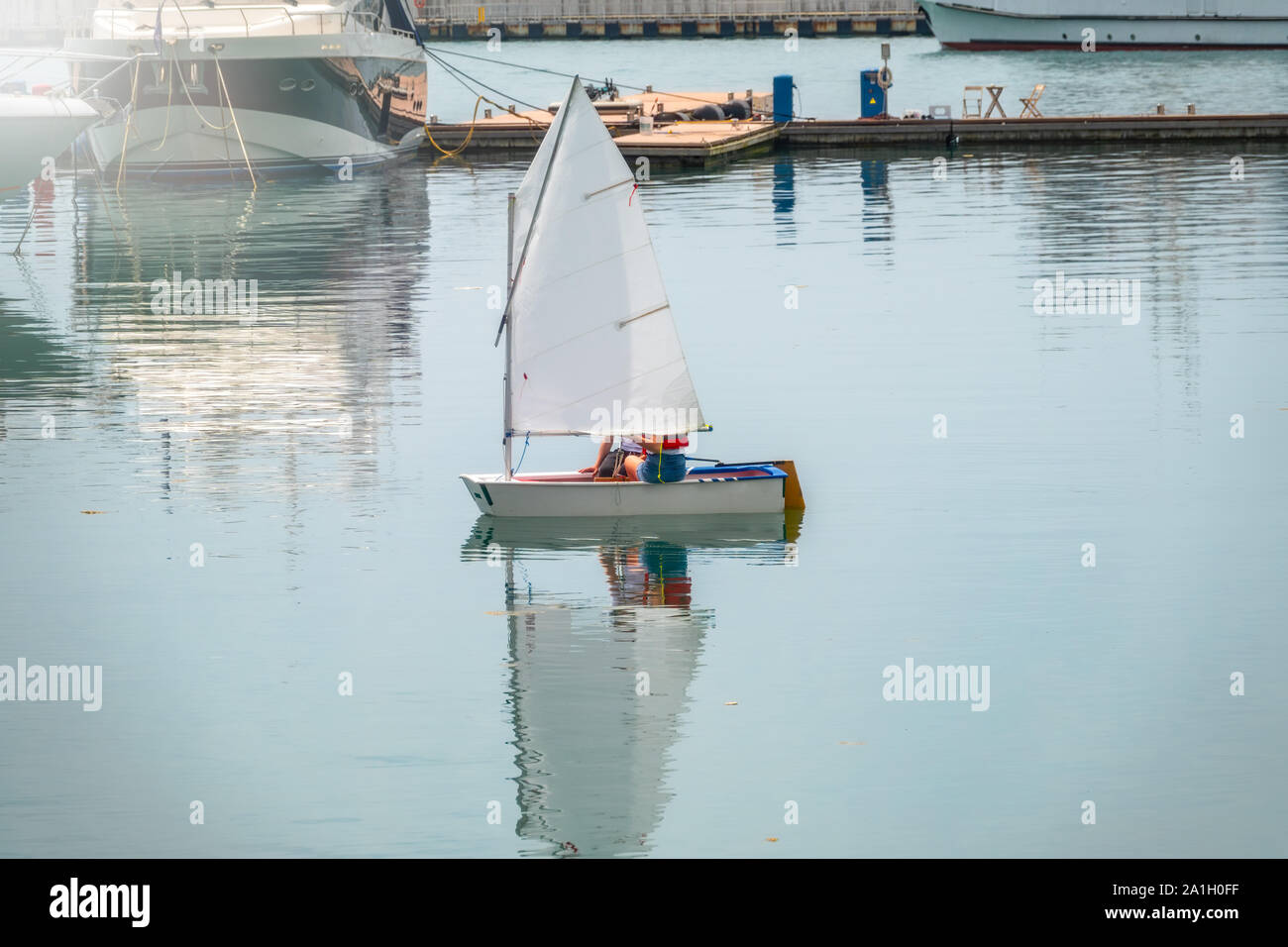 Two girls are sailing on a small sailing boat. Teamwork by junior ...