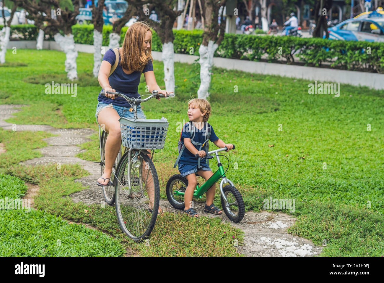 Happy family is riding bikes outdoors and smiling. Mom on a bike and ...