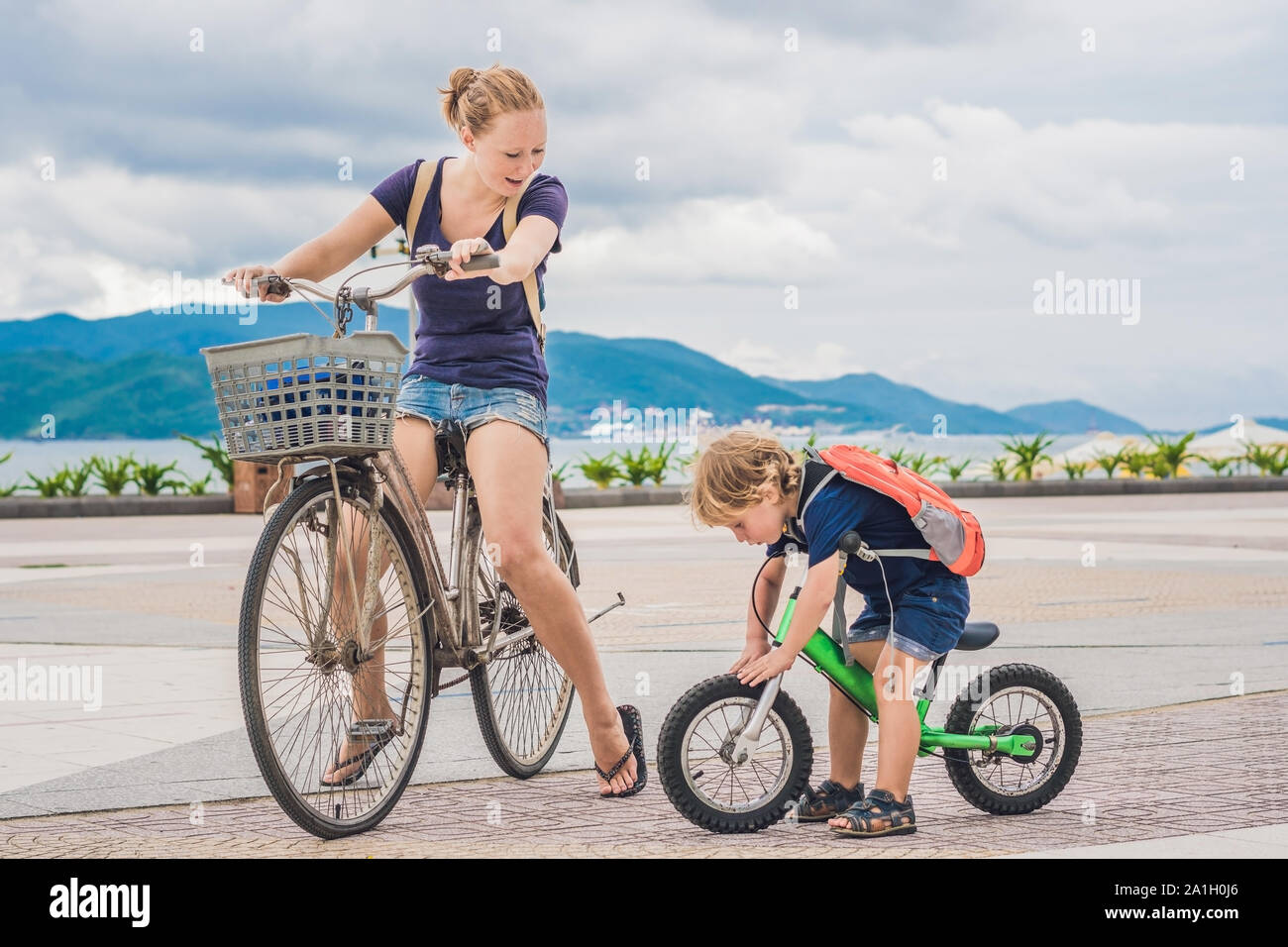 Happy family is riding bikes outdoors and smiling. Mom on a bike and ...