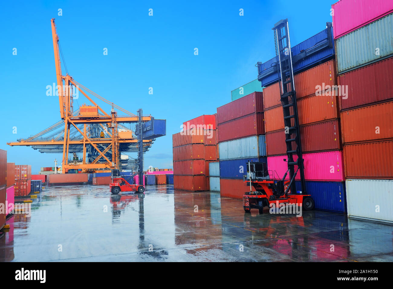 Two container handlers are storing containers up the stack. To wait for ...
