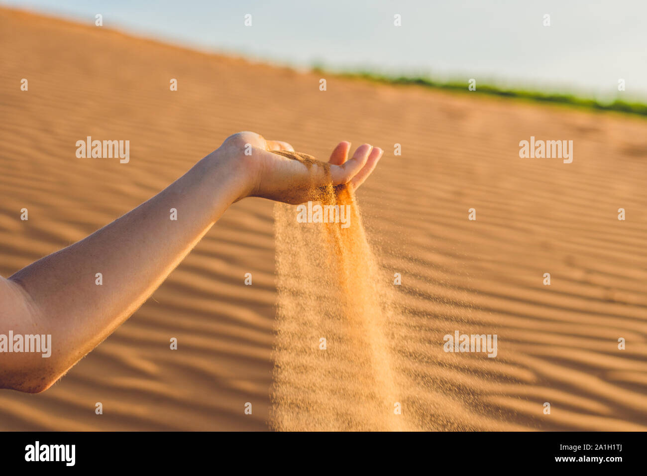 Sand slipping through the fingers of a woman's hand in the desert Stock ...