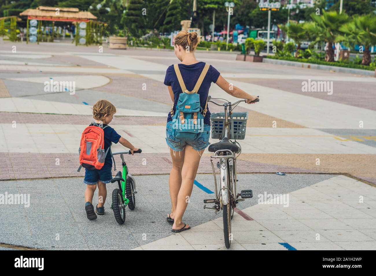 Happy family is riding bikes outdoors and smiling. Mom on a bike and ...