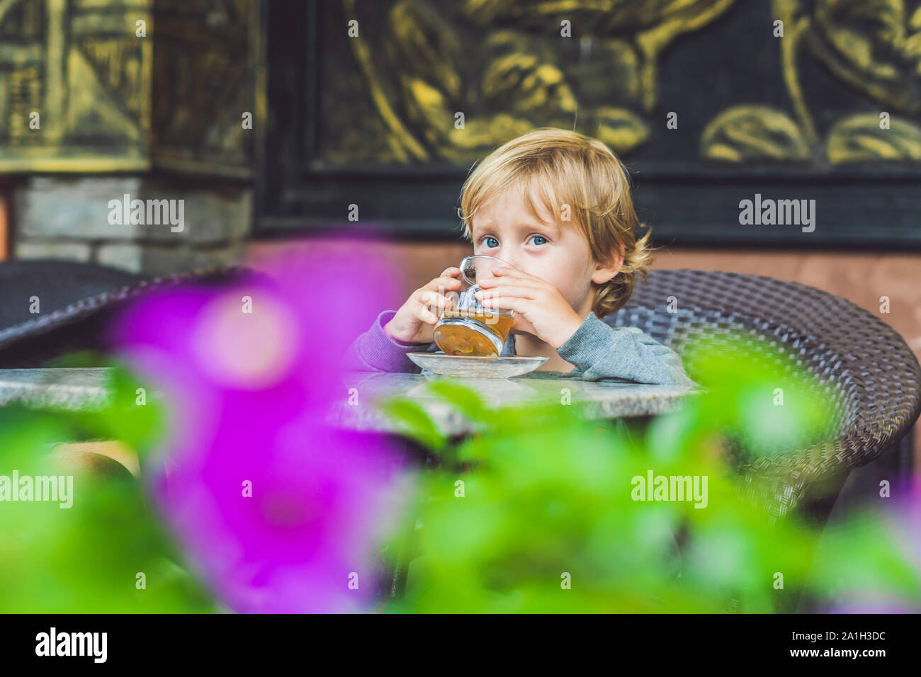 Cute little boy drinking tea in cafeteria Stock Photo - Alamy