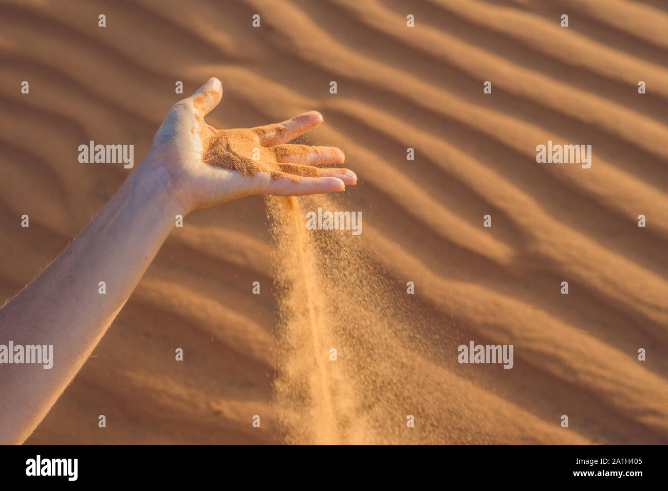 Sand slipping through the fingers of a woman's hand in the desert Stock ...