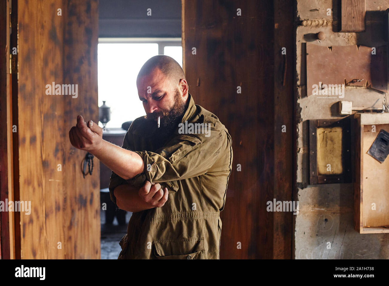 Man's den workshop inside man rolling up sleeves before work Stock ...