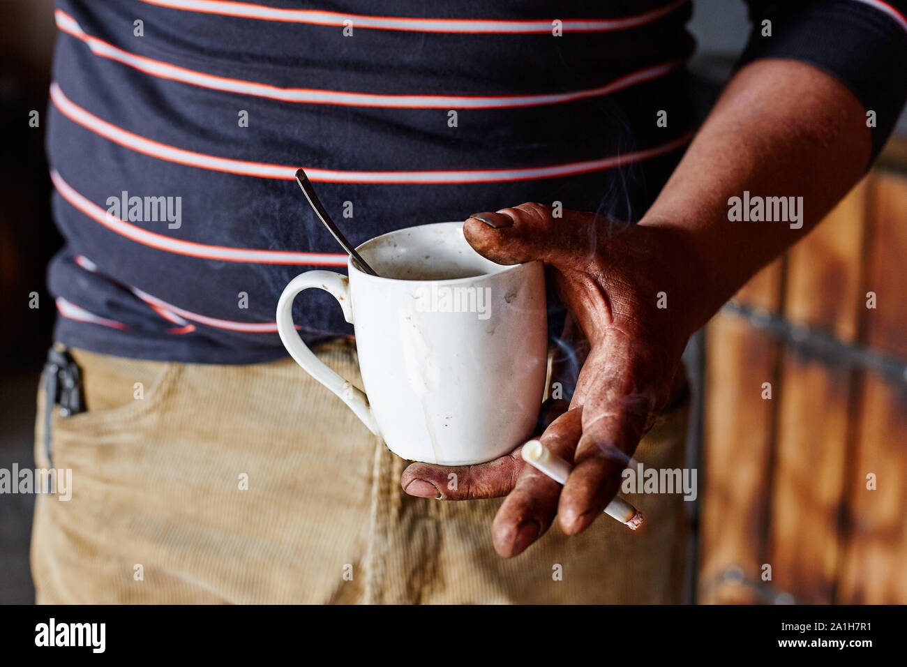 dirty hand holding a Cup with a drink and a cigarette Stock Photo - Alamy