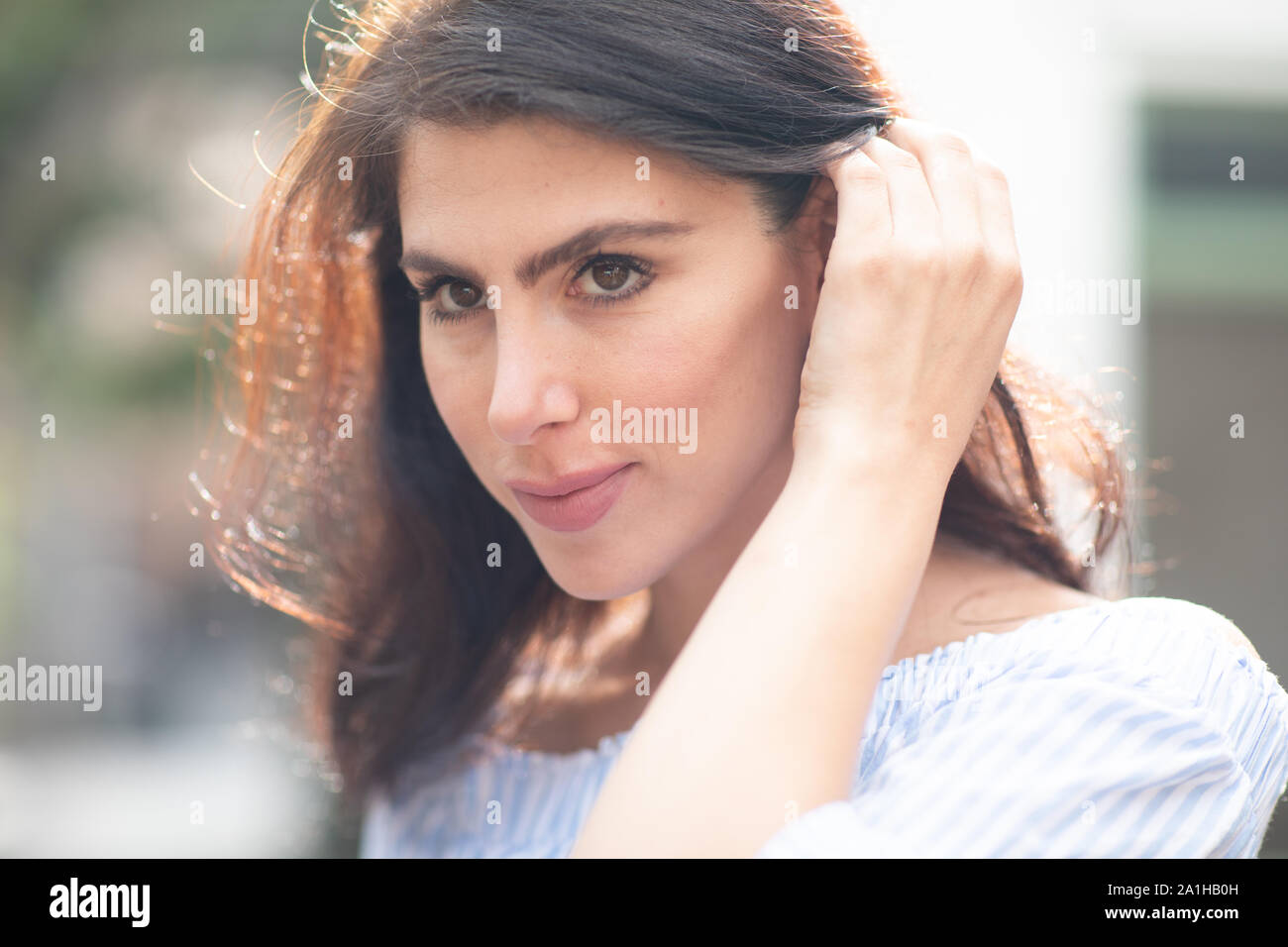 Shy But Flirty Brunette Tucking Her Hair Behind Her Ear Closeup Sunny
