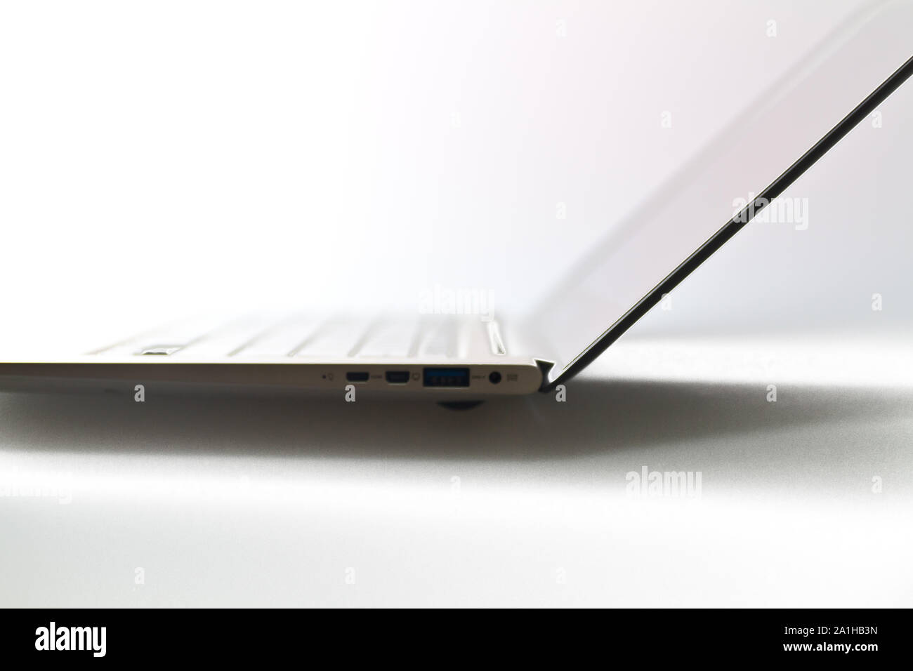 a modern metal laptop with opened lid against white background for ...