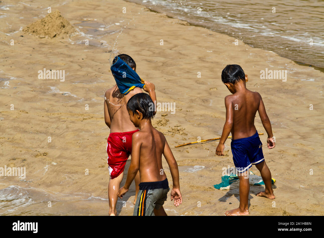 Unknown Kids playing with sand and water by the river in Belaga Sarawak ...