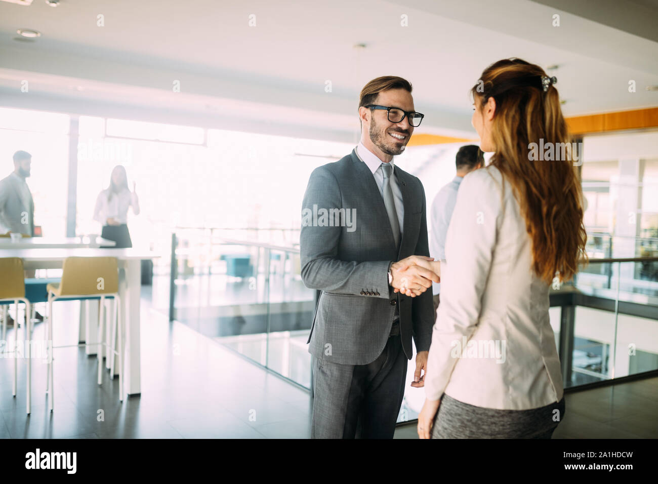 Business people discussing over documents in office lobby Stock Photo ...