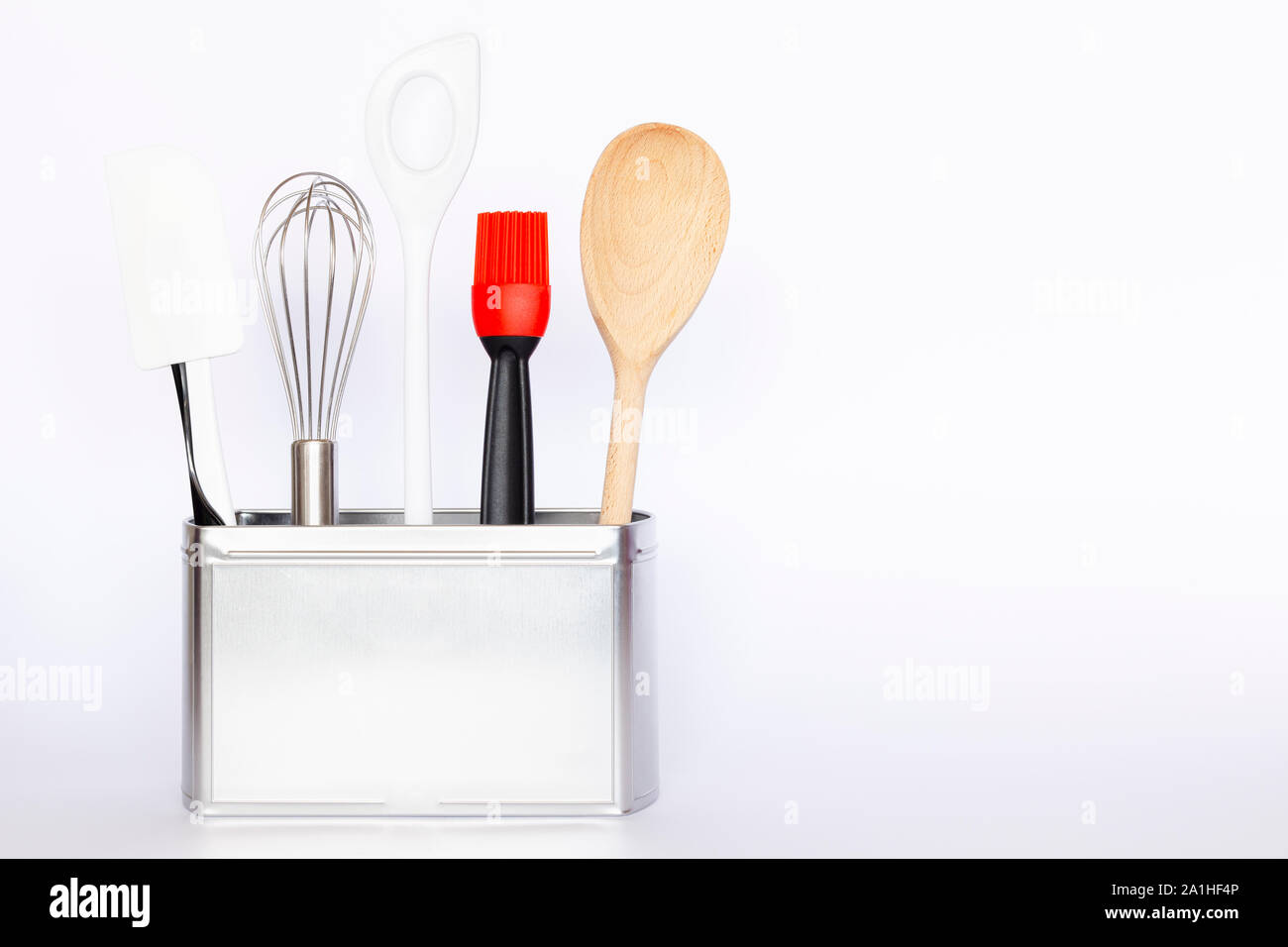 Assortment of kitchenware and cooking tools in a square silver colored ...