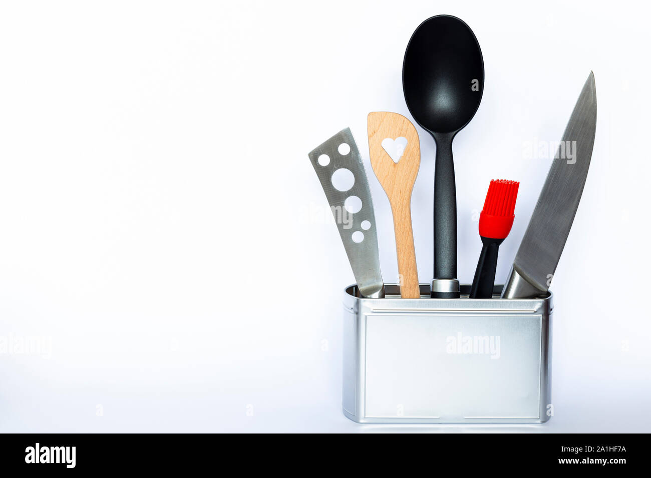 Assortment of kitchenware and cooking tools in a square silver colored ...