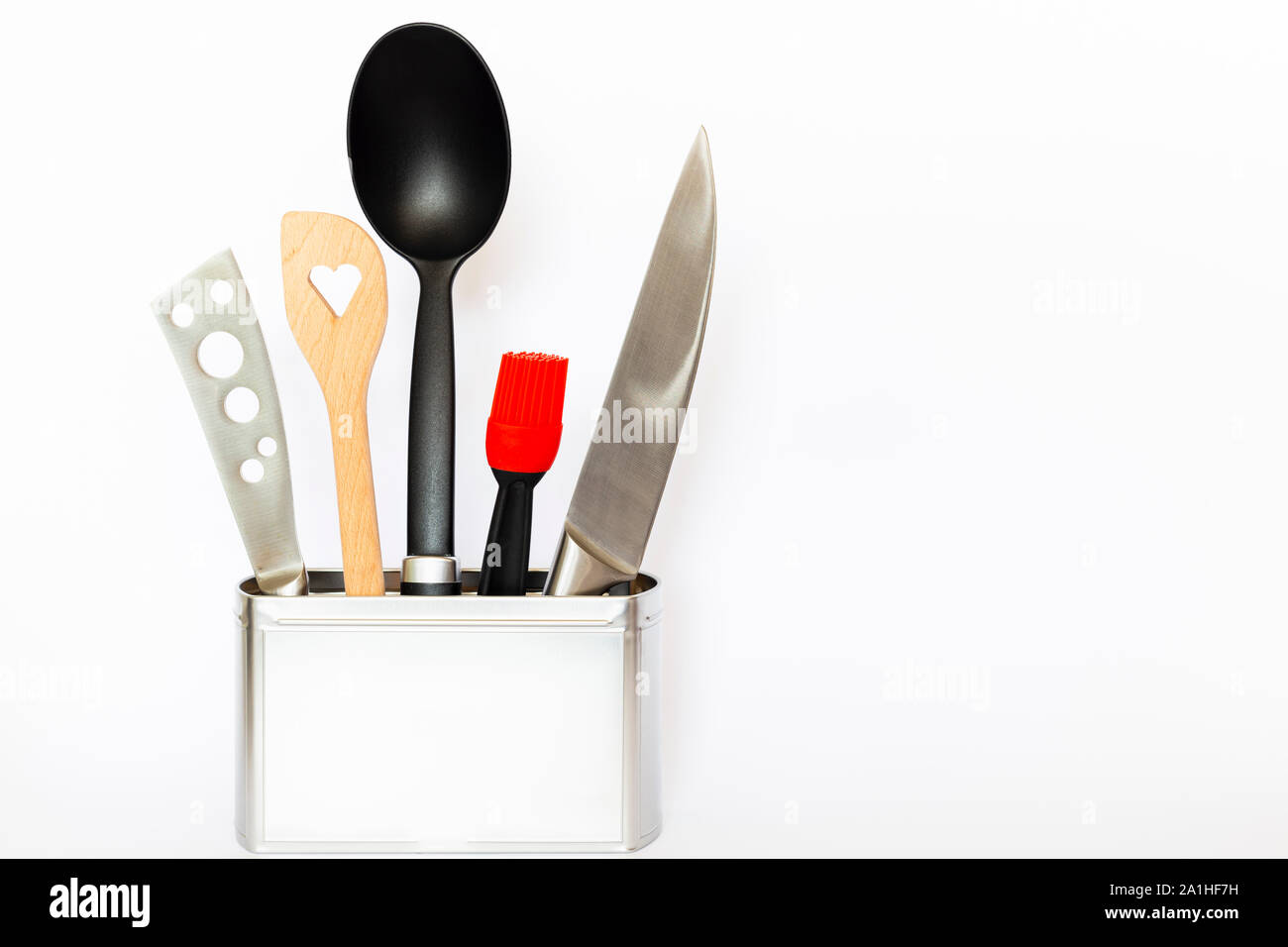 Assortment of kitchenware and cooking tools in a square silver colored ...