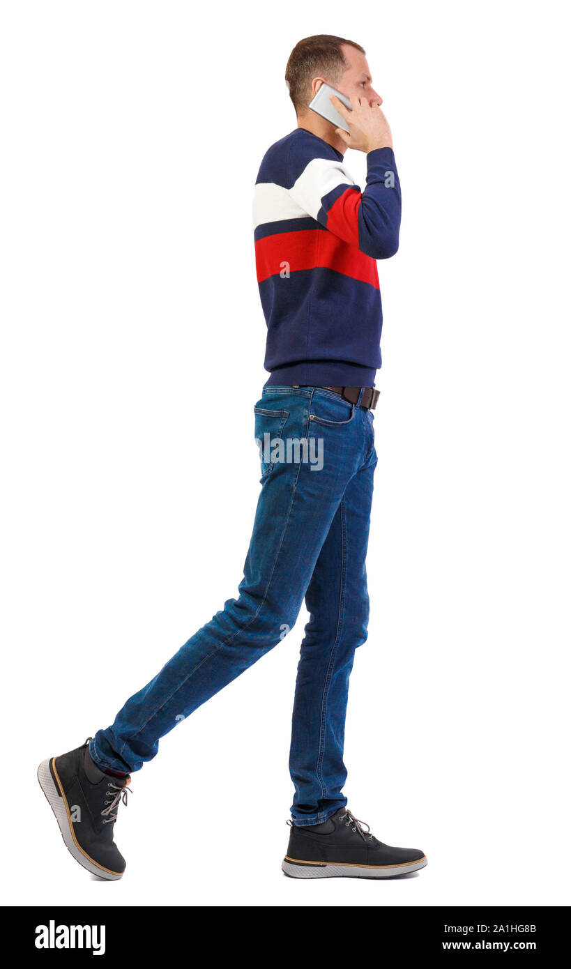 a side view of man walking with a mobile phone. backside view of person ...