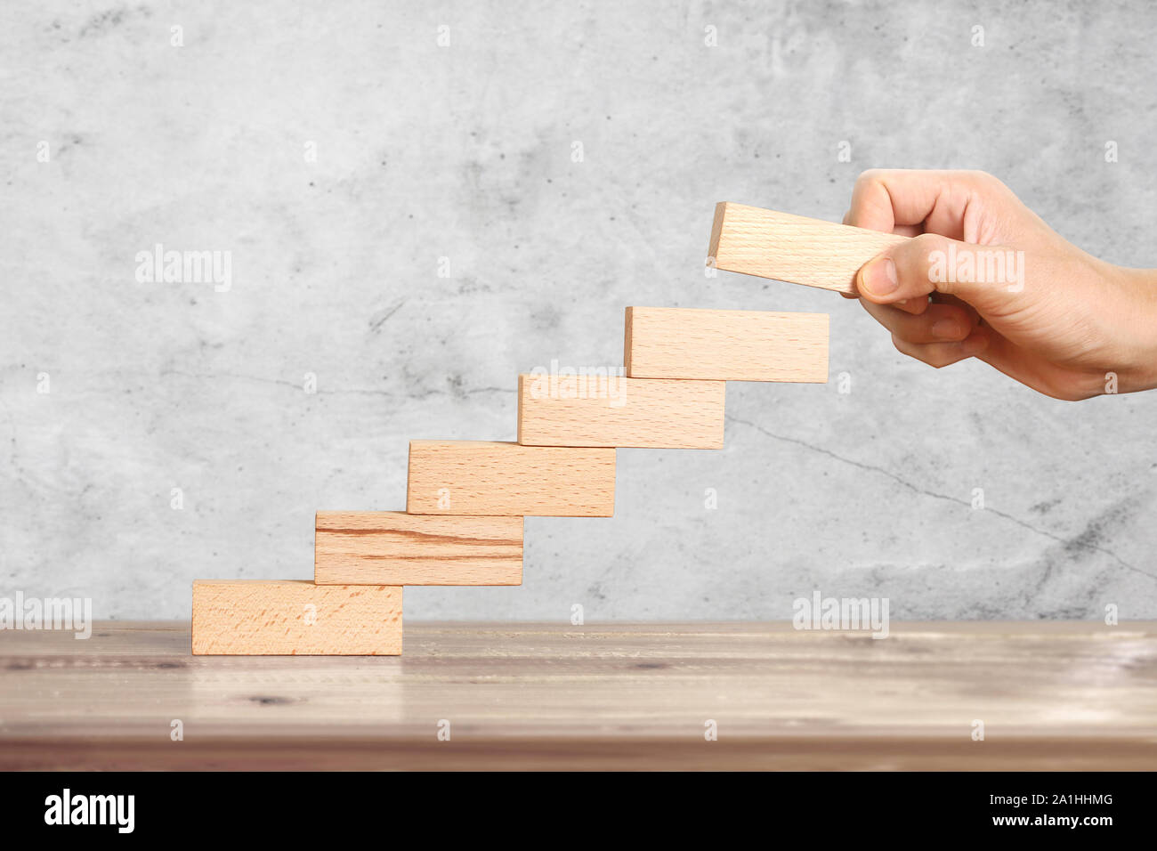 Hand liken person stepping up wood block stacking as step stair ...