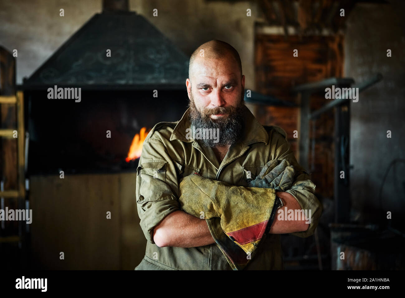 Portrait of a brutal, confident blacksmith, a man with a beard ...