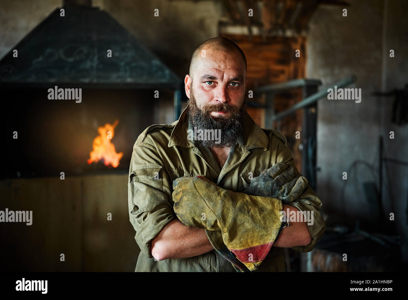 Portrait of a brutal, confident blacksmith, a man with a beard ...