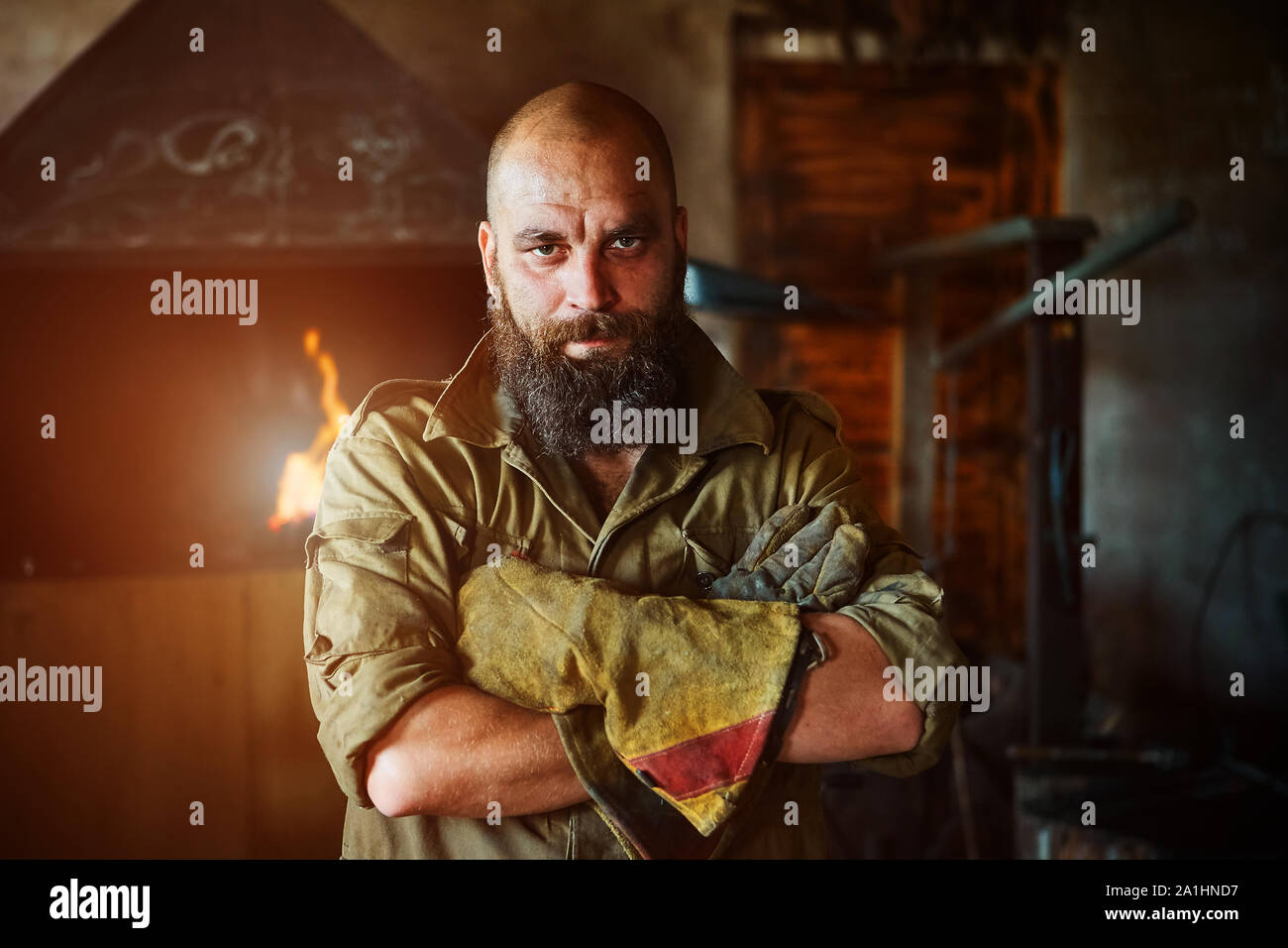 Portrait of a brutal, confident blacksmith, a man with a beard ...