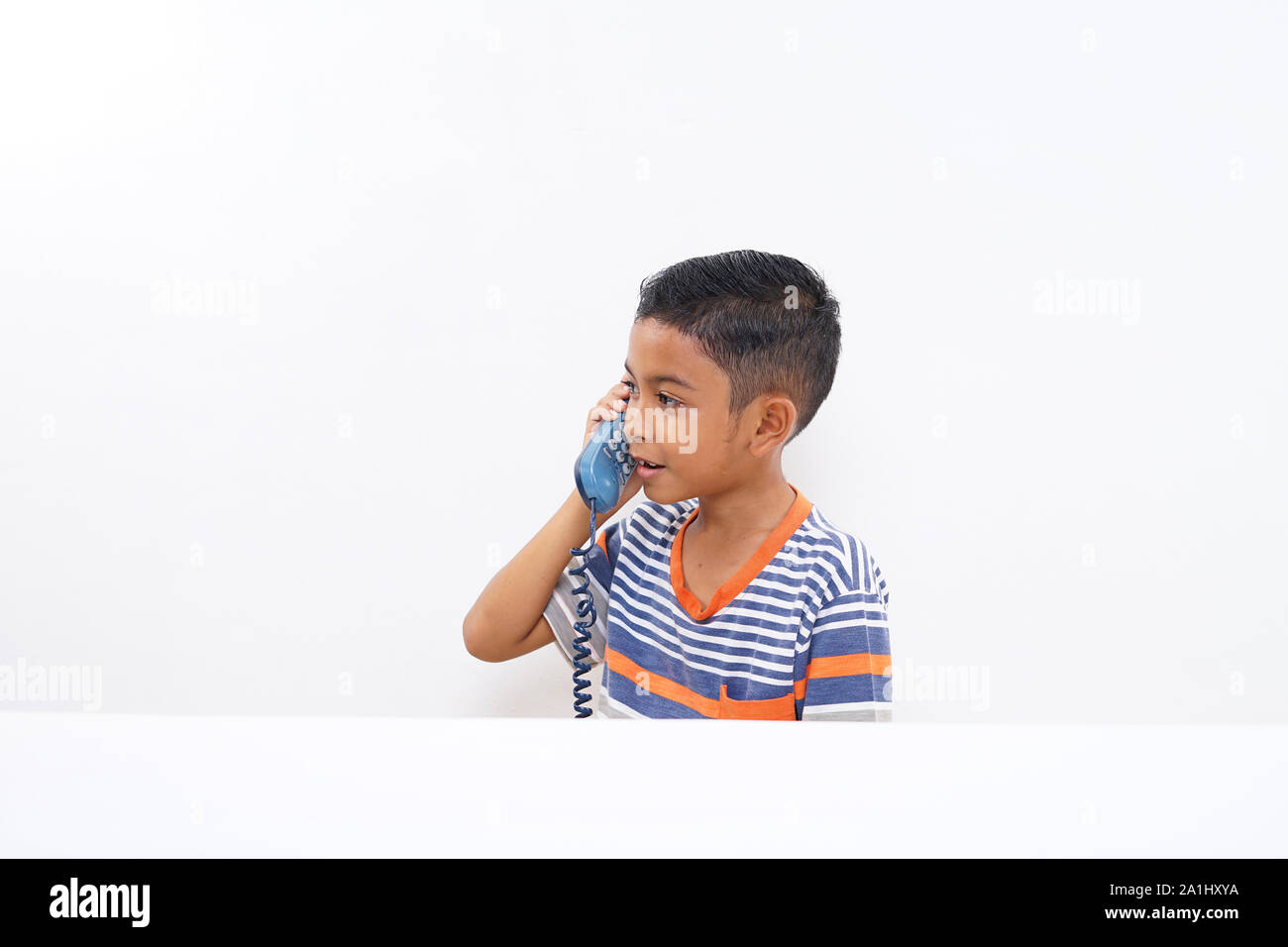 Cute little boy talking on the landline phone Stock Photo - Alamy