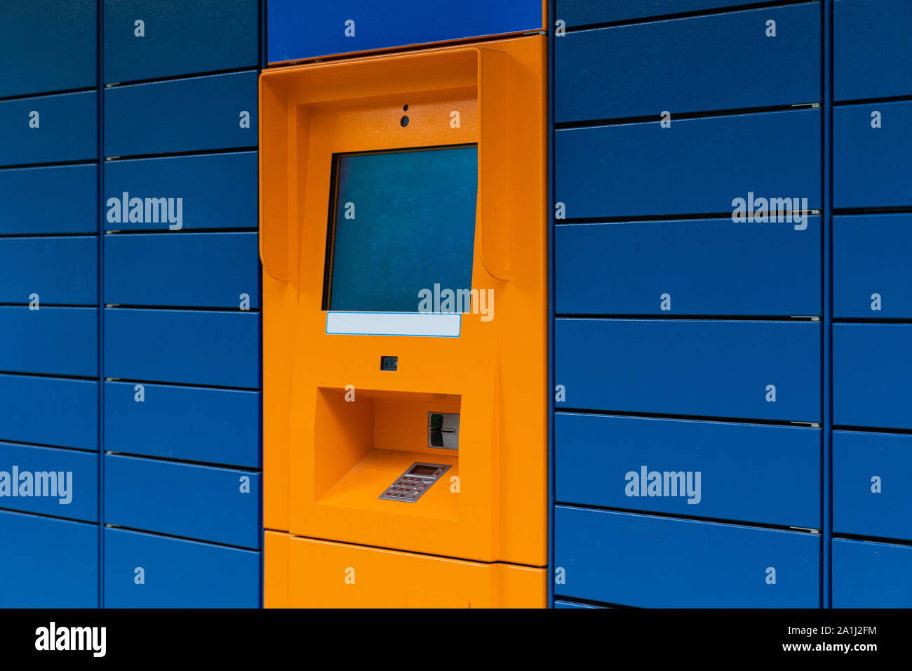 Orange cashpoint minibank with blank copyspace screen on blue panel ...