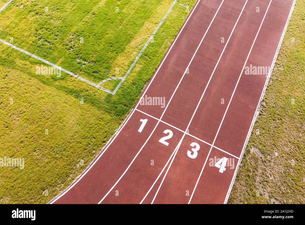 Top view of red running tracks and green grass lawn. Infrastructure for ...