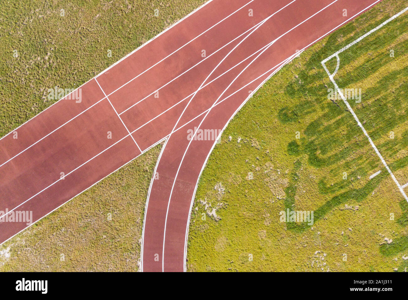 Top view of red running tracks and green grass lawn. Infrastructure for ...