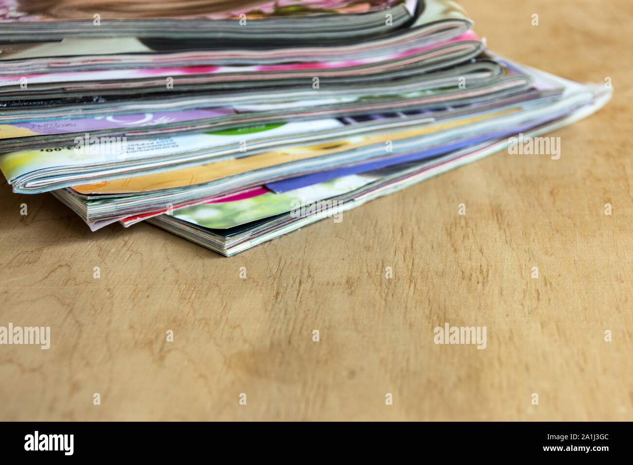 Stack of colorful magazines on the office wooden table. Copy space ...