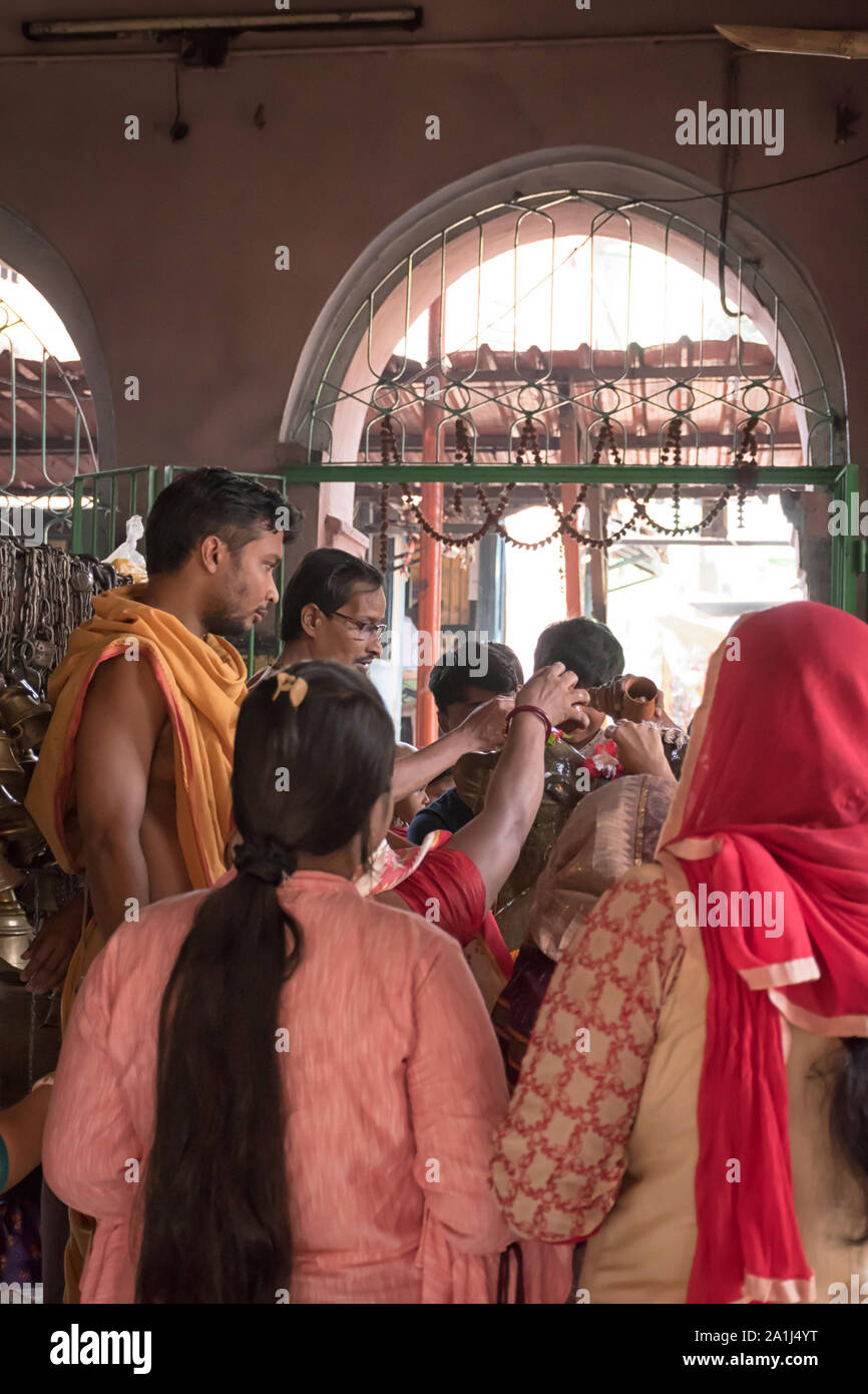 Group of people doing puja to statue of Stones at Baba Taraknath Temple ...