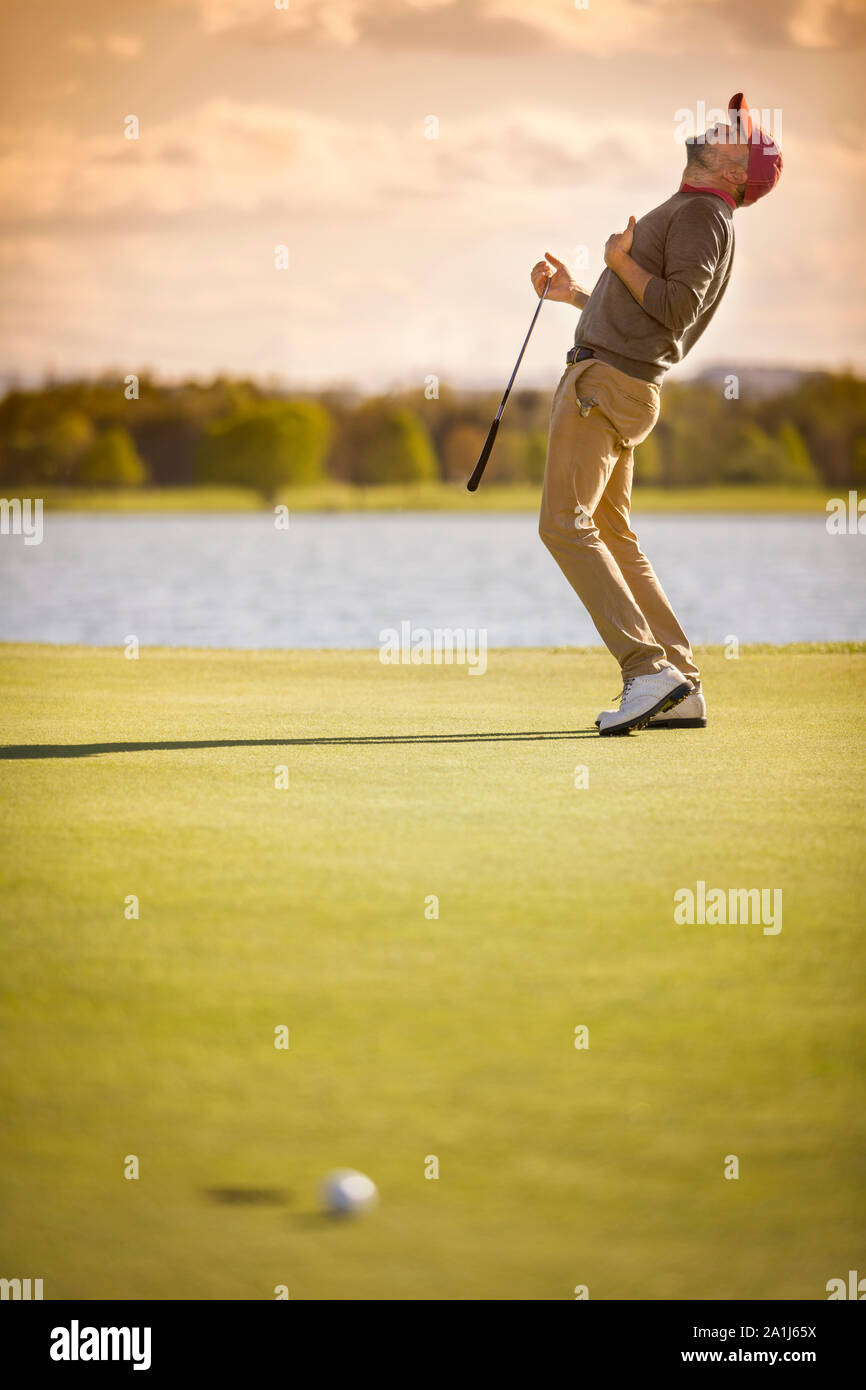 Male golf player shot past hole Stock Photo - Alamy