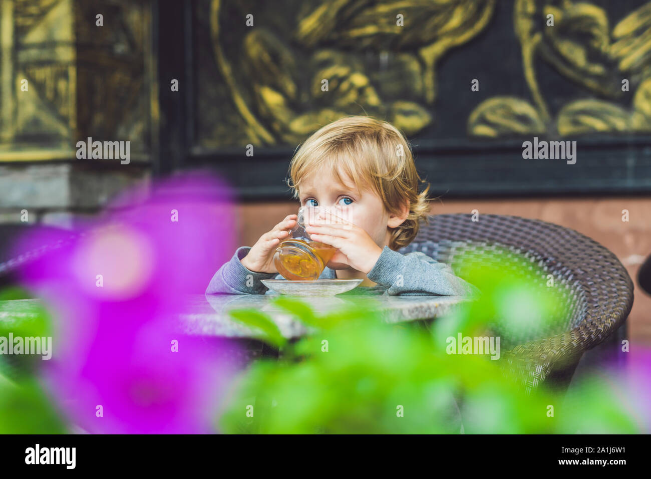 Cute little boy drinking tea in cafeteria Stock Photo - Alamy