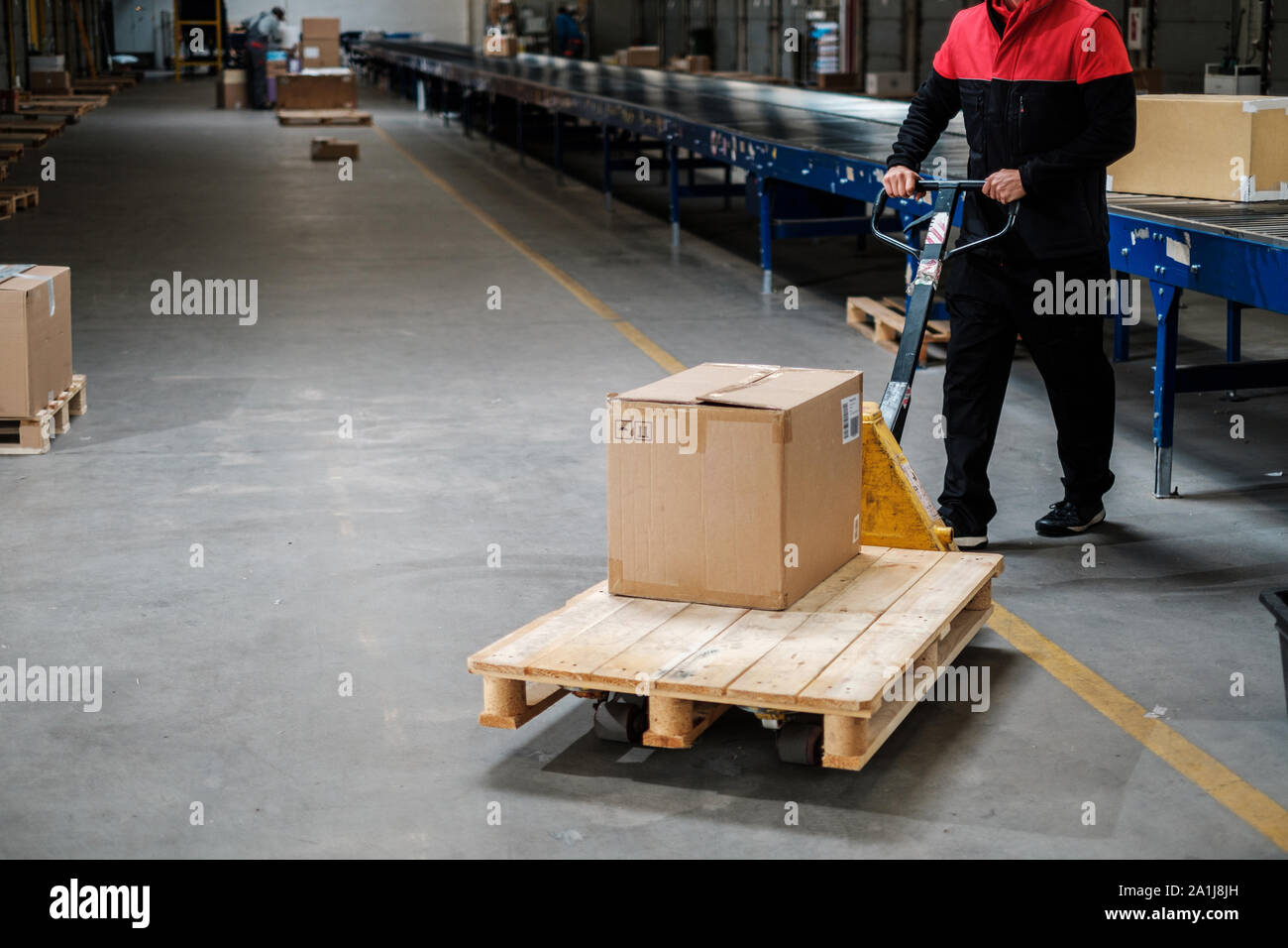 Warehouse worker with a pallet rack Stock Photo - Alamy