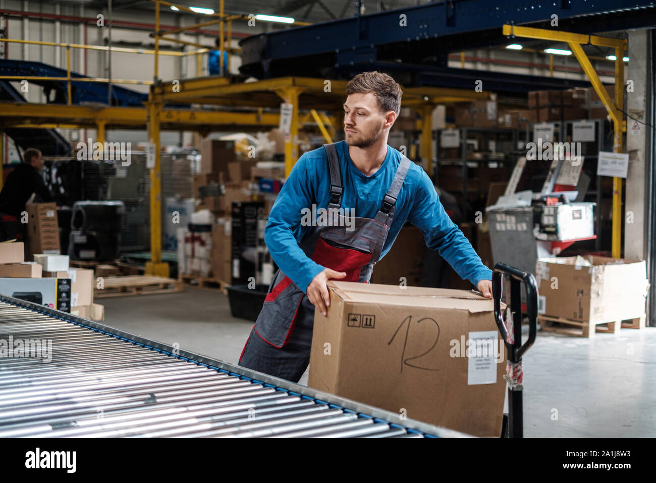Warehouse worker working on a conveyor line Stock Photo - Alamy