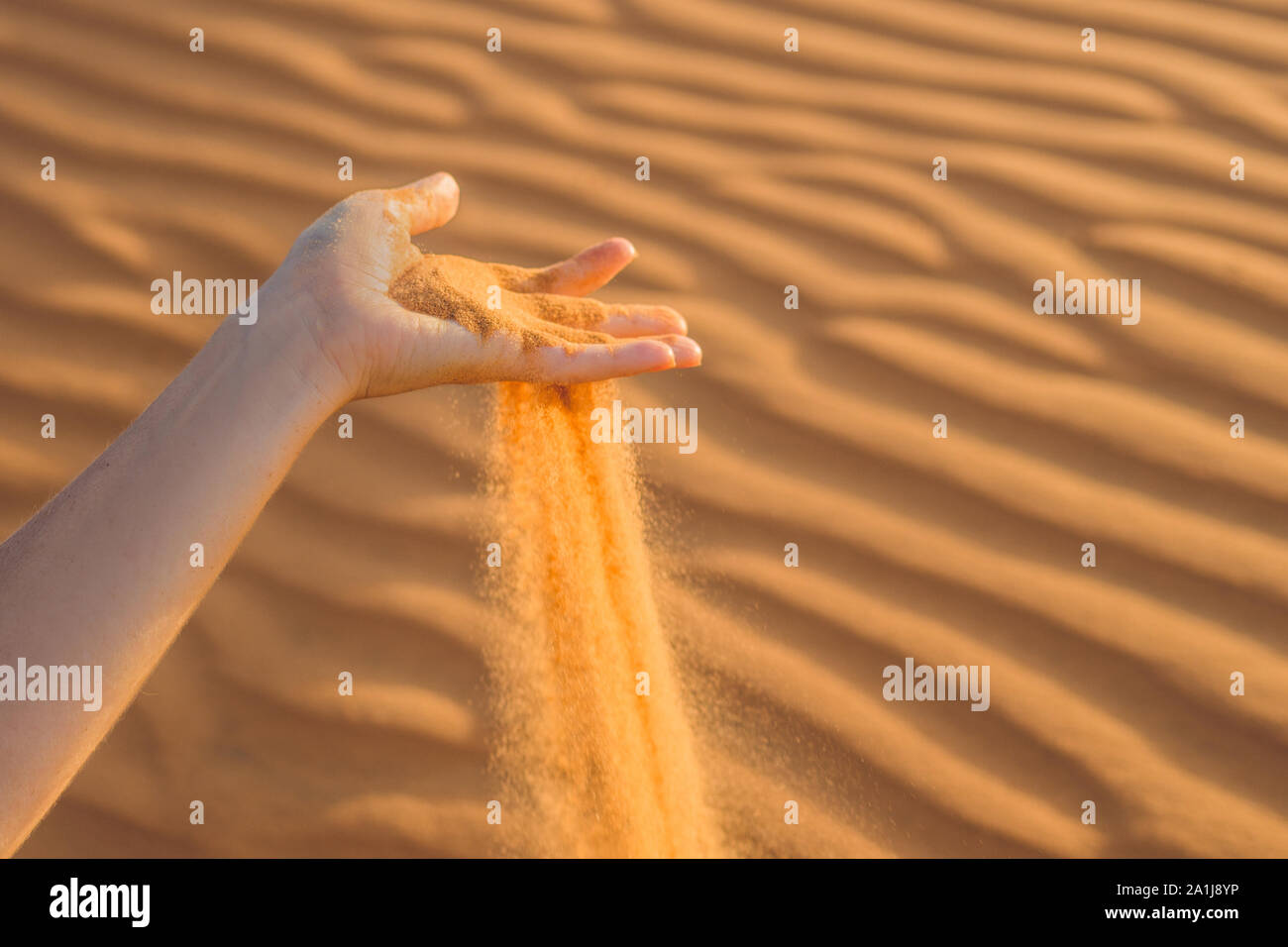 Sand slipping through the fingers of a woman's hand in the desert Stock ...
