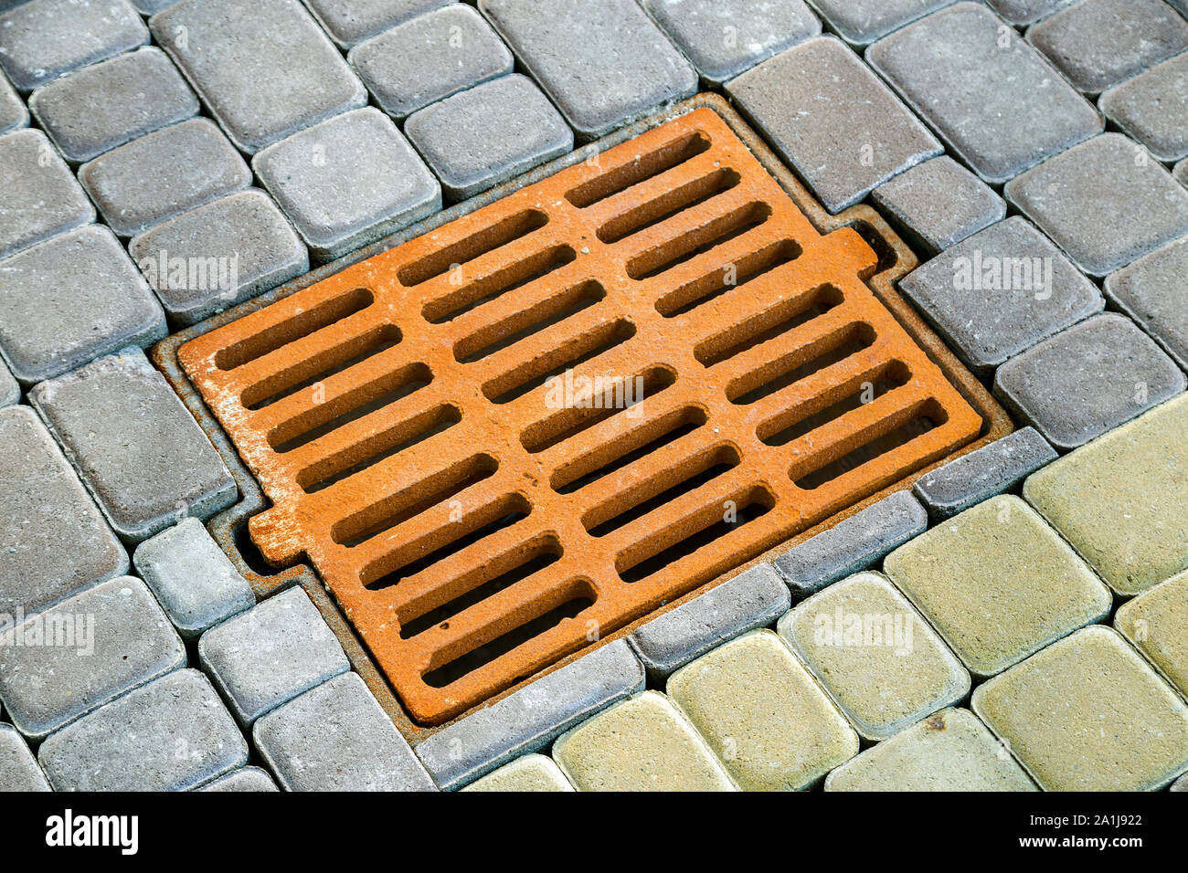 Old rusted metal gutter for rain water on the stone paved sidewalk ...