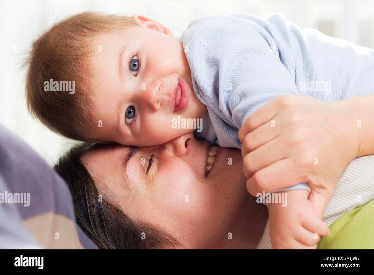 Joyful mother cuddling her baby boy with affection Stock Photo - Alamy