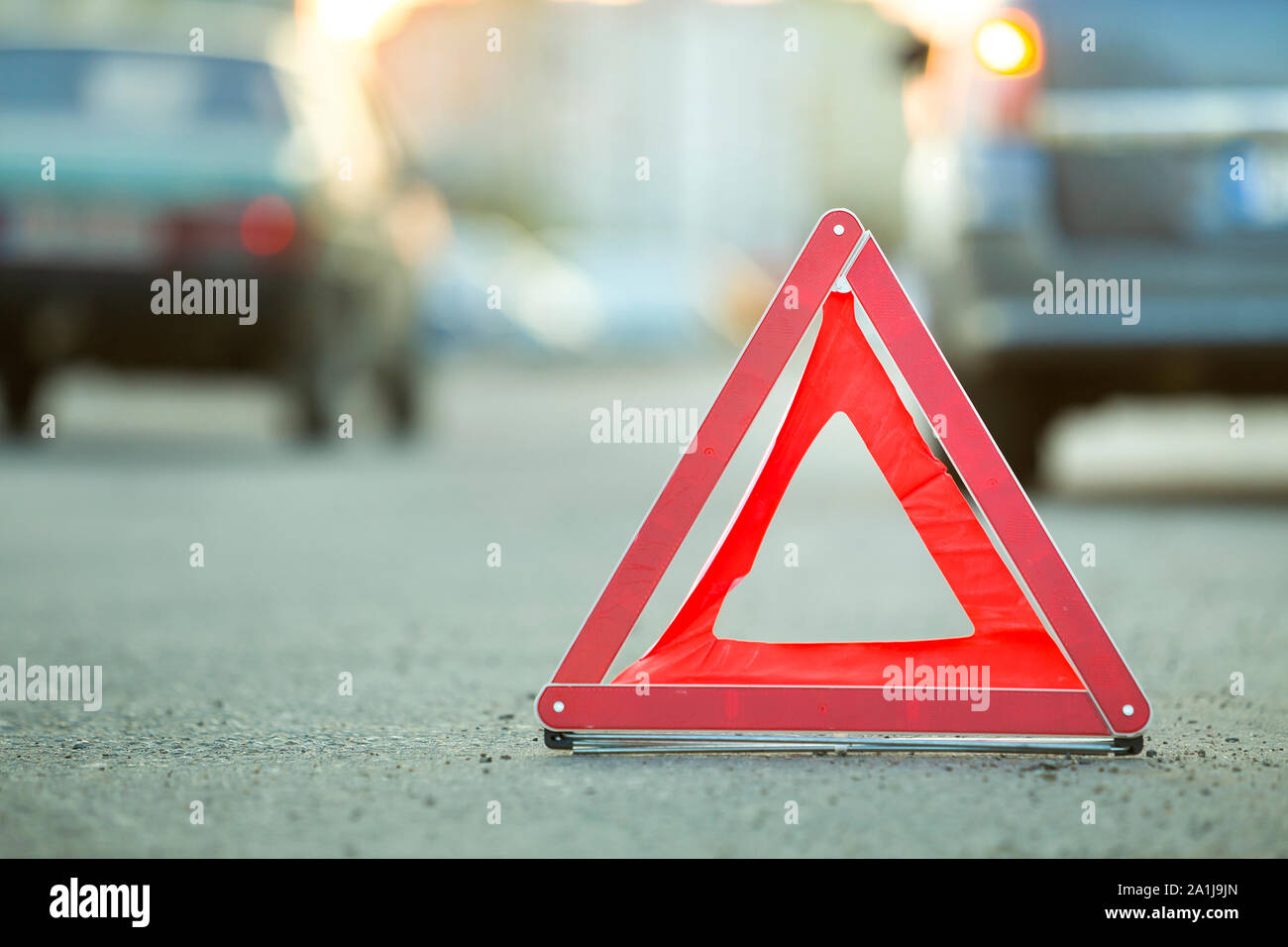 Red emergency triangle stop sign and broken car on a city street Stock ...