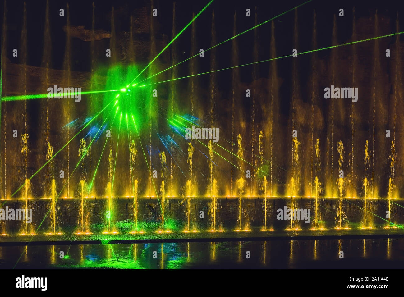 Multicolored dancing water jet fountain in the dark Stock Photo - Alamy