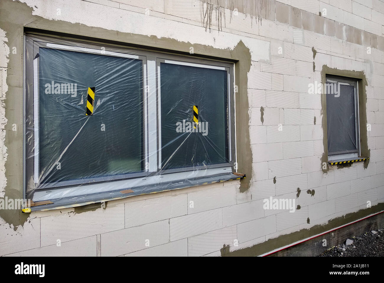 Windows of a house under construction covered with protective plastic ...