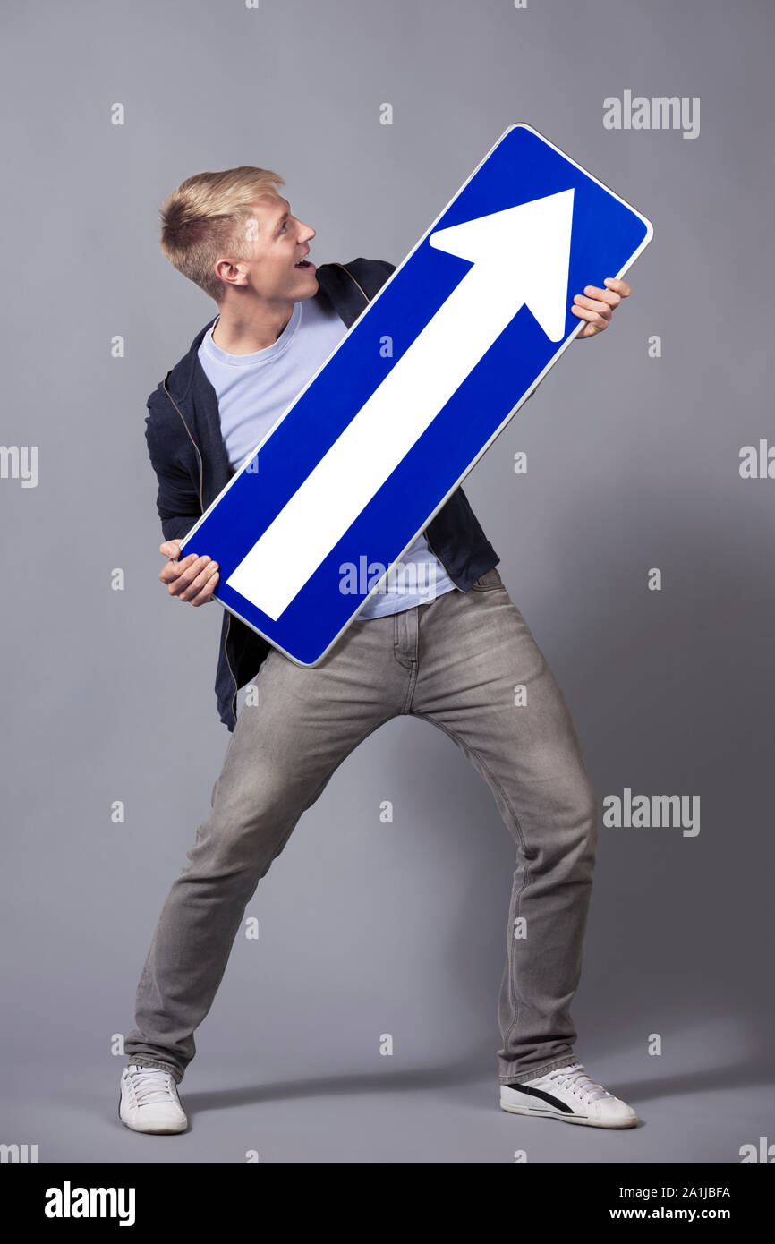 Friendly man holding upward pointing direction arrow sign Stock Photo ...
