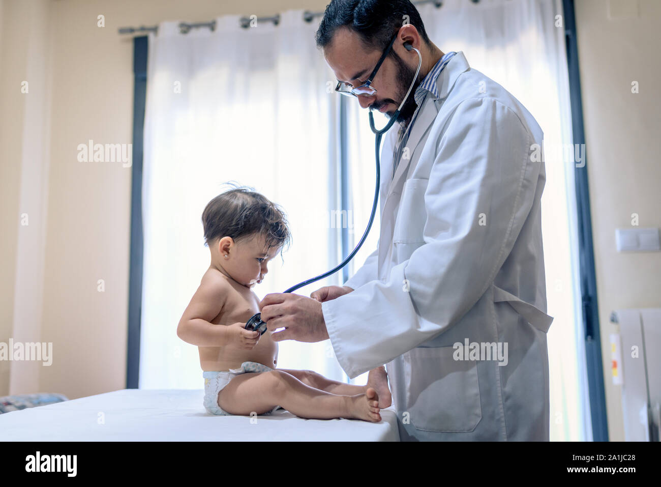 Doctor observing a one-year-old baby Stock Photo - Alamy