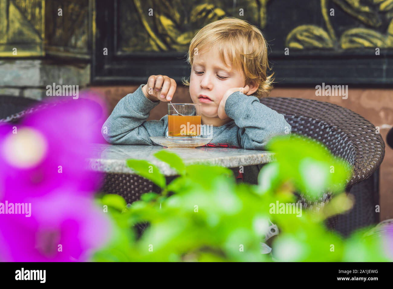 Cute little boy drinking tea in cafeteria Stock Photo - Alamy